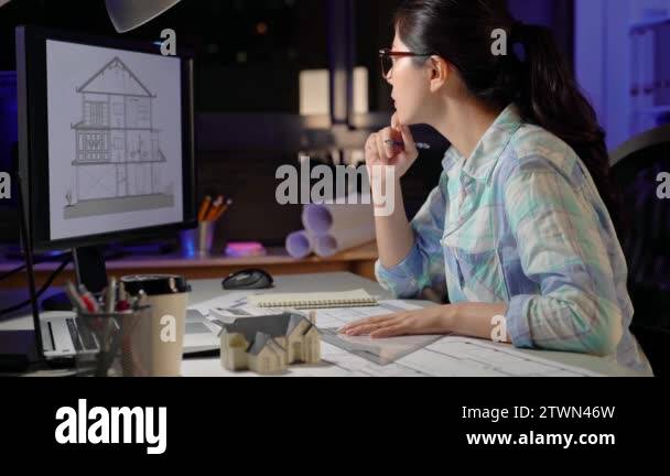 Female Asian architect draws down the picture on the computer by her ...