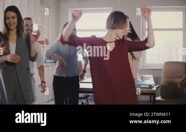 Happy European woman leader dancing at office party. Multiethnic ...