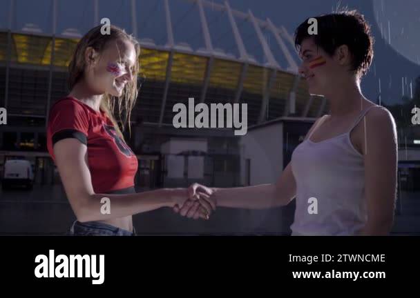 Champions League, two young girls football fans in the rain are shaking ...