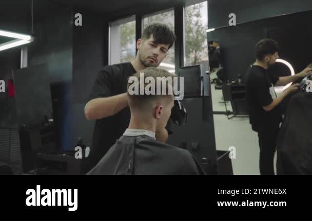Male haircut with electric razor. Barber makes haircut for client at ...