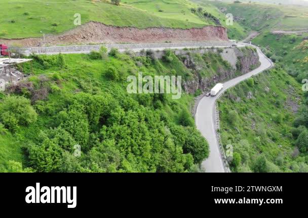 A driveway surrounded by green hills from a birds eye view. 4k Stock ...