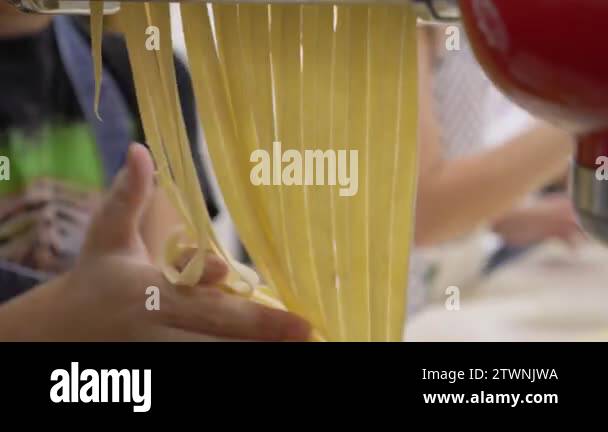 Making noodles. Making spaghetti with a traditional style pasta machine ...