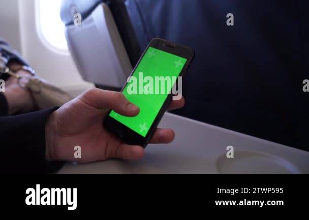 Close up shot of a male passenger on an airplane, scrolling up and ...