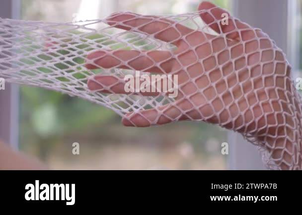 close-up. Female hands test the integrity of kapron stockings. a torn ...