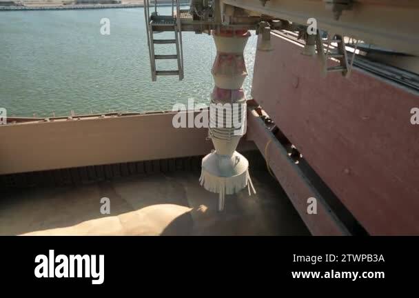 Close view of ship loading grain crops on bulk freighter via trunk to ...