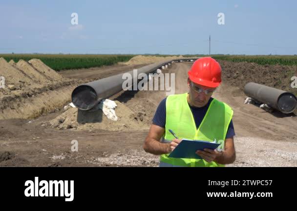 Engineer Writing on Clipboard at Gas Pipeline Construction Site. Pipes ...