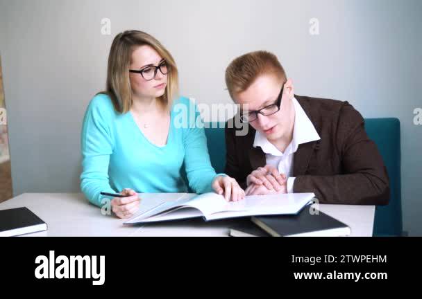 Positive male and female students doing homework together spending time ...