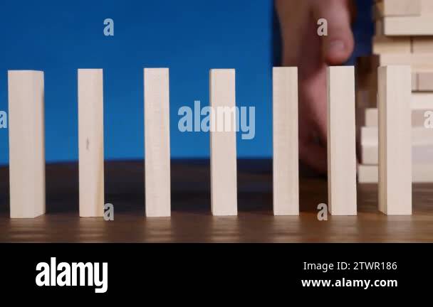 Domino effect concept with wooden blocks falling on each other Stock ...
