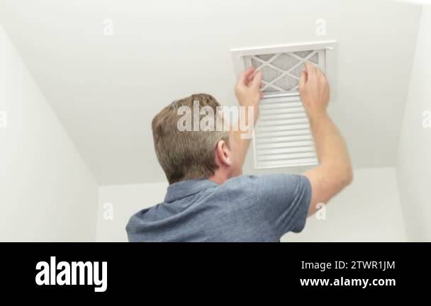 Examining a Small Air Duct with a FlashlightMale inspecting air ducts ...