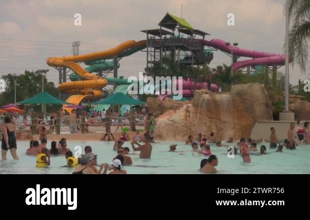 A Water Park Scene with Water Tube Slides in the Distance and Visitors ...