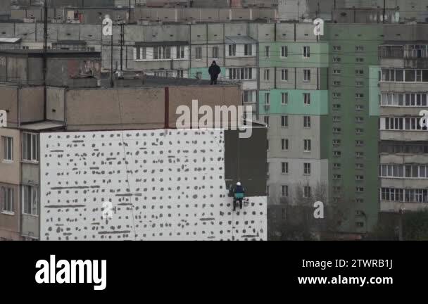 High-altitude work. The man works on high-rise works cladding ...