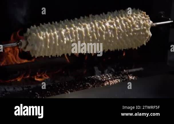 Cooking traditional layered cake - sakotis on an open flame outside ...