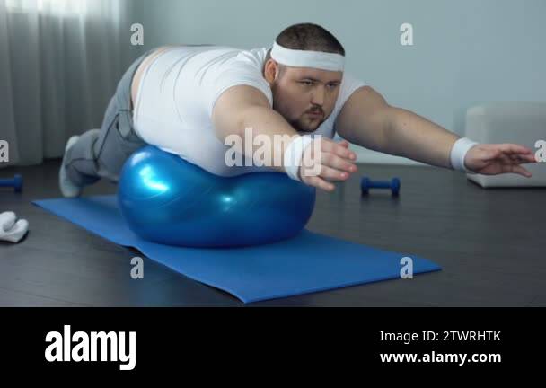Obese hardworking man practicing static exercise, strength training ...