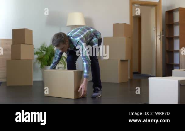 Student with sad face leaving dormitory taking box with his stuff ...