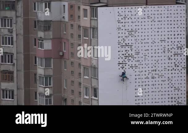 High-altitude work. The man works on high-rise works cladding ...