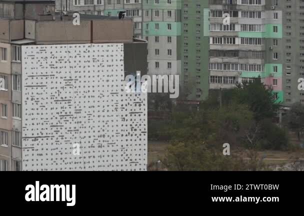 High-altitude work. The man works on high-rise works cladding ...