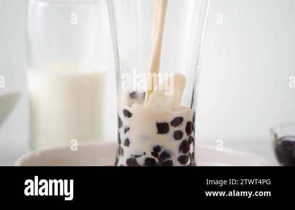 Pouring milk tea in drinking glass with tasty popular taiwan tapioca ...