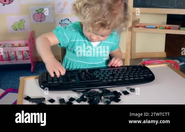 Sweet little child boy girl playing with broken keyboard keys Stock ...