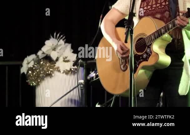 Close up of woman guitar player. Female guitarist hits the strings of ...