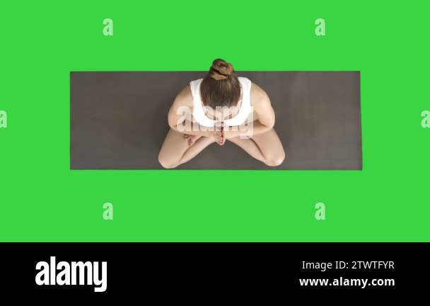 Young yogi woman practicing yoga, making namaste gesture in lotus pose ...
