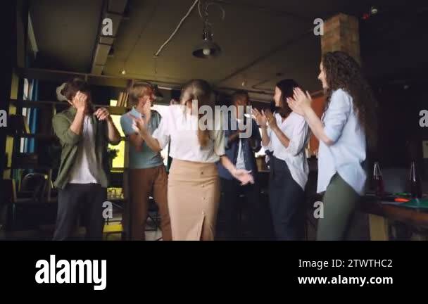 Company employees are dancing at corporate party in modern loft style ...