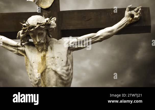 Jesus Christ crucified. The Crucifixion. Christian cross with Jesus Christ statue over stormy ...