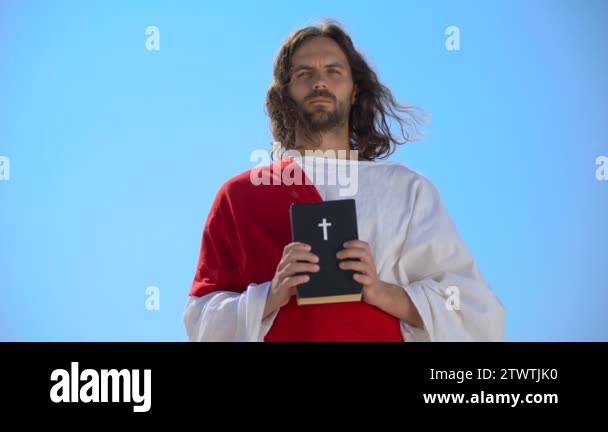 Strict God holding Bible against blue sky, reminding of faith and ...
