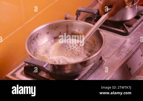 Deep frying puri ( poori ) Woman cooking recipe in indian kitchen ...