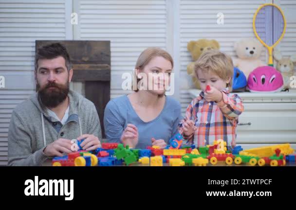 Young family play game with construction plastic blocks. Family games ...