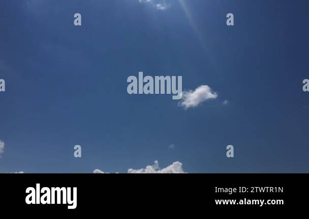 white clouds disappear in the hot sun on blue sky. Time-lapse motion ...