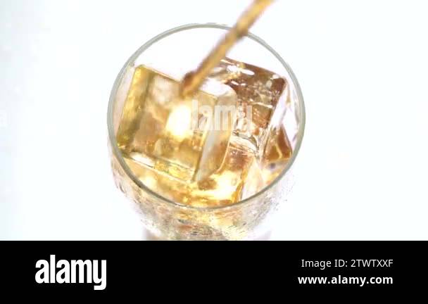 Coca Cola is poured into a glass from a bottle. White background. View ...