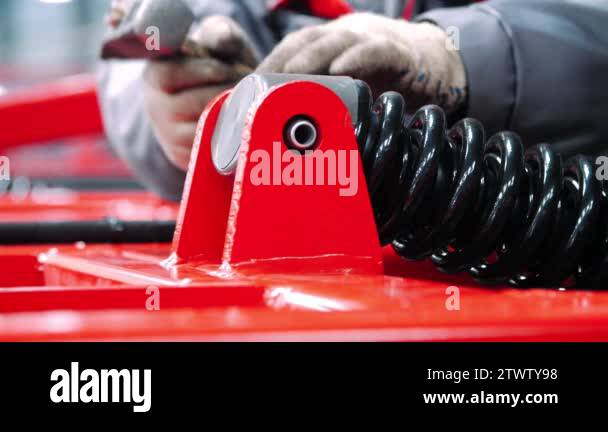 Mechanic working in assembly workshop heavy units. Fastening of shock ...