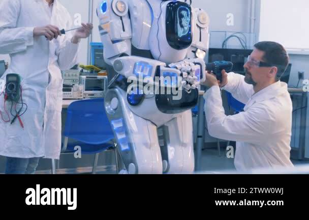 Two engineers are repairing a human-like robot Stock Video Footage - Alamy