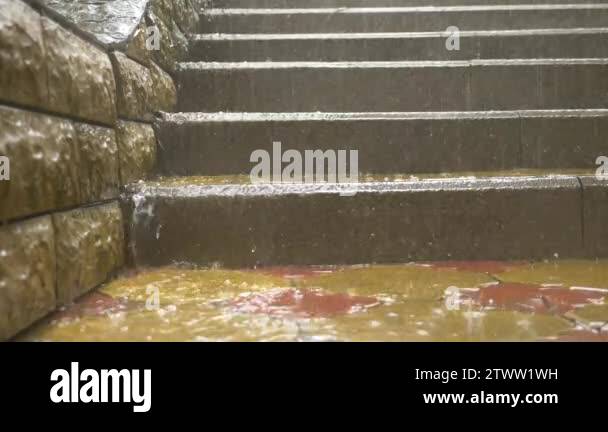 streams of water pour down the steps of the stairs in the park during a ...