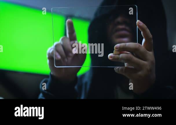 Hacker using clear tablet with green screen monitor background Stock ...