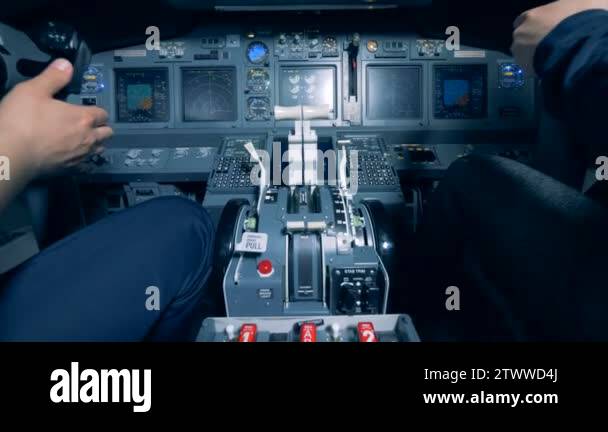 Two men are sitting in a cockpit of a flight simulator and are ...