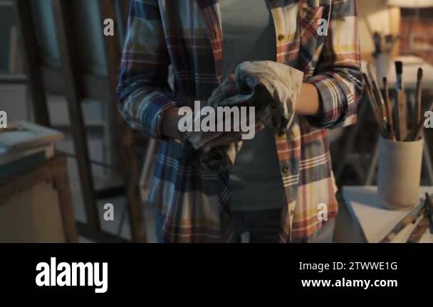 Young female artist and painter in her studio, she is cleaning her ...