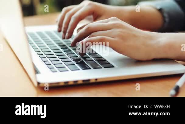 Female hands with a manicure print on the laptop keyboard. Printing and ...
