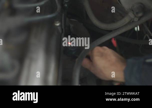 A man installs a knock sensor on the engine to check and diagnose the engine, inspection Stock ...