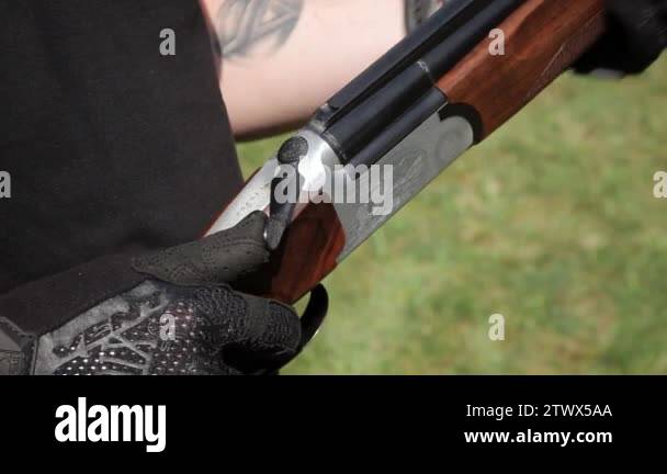 A close-up view of rifle. Mans hands demonstrates the principle of ...