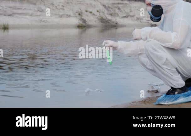 Man in a protective costume and gas mask of respirator observes a ...