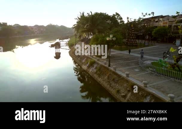 motion along nice modern riverfront with palm trees to woman doing ...
