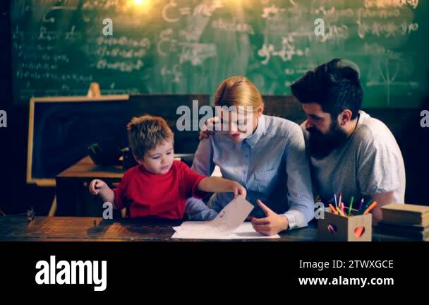 The boy and his parents draw in the school classroom on the background ...