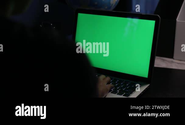 Over the shoulder view of typing and watching on computer . Green ...