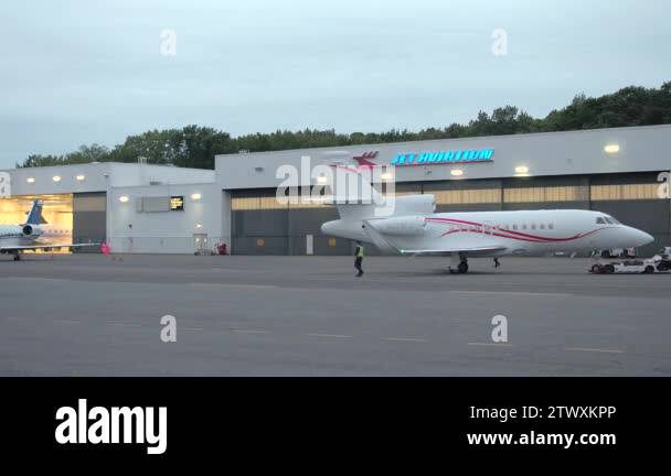 CLOSE UP: Line technicians working in Teterboro Airport, operating aircraft towing vehicle and ...