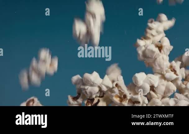 White fluffy pieces of popcorn fall at a slow pace and pile on each ...