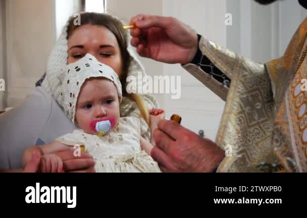 the holy father smears his forehead and handles to the infant with ...