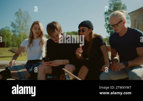 Stylish Cool Teenagers Chilling on the Benches in the Park, Using ...