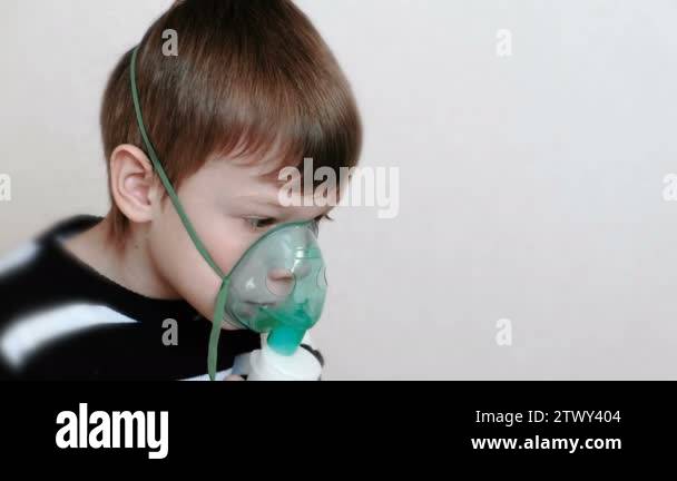 Use nebulizer and inhaler for the treatment. Boy inhaling through ...
