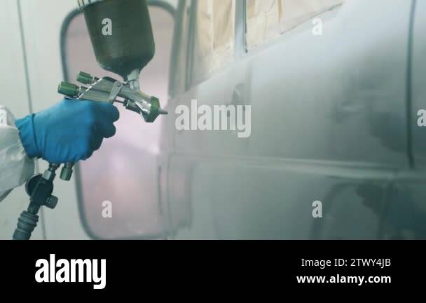 Paint is getting smoothly sprayed onto the car. Industrial spray ...